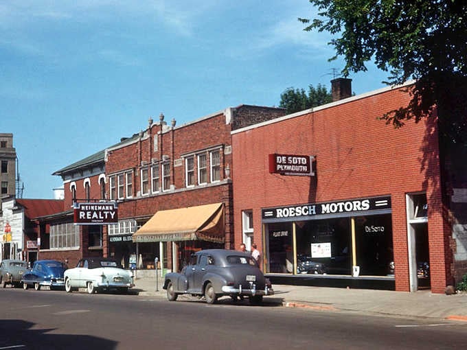 Classic cars parked along vintage storefronts create a scene straight from "American Graffiti," celebrating timeless small-town charm and nostalgia.