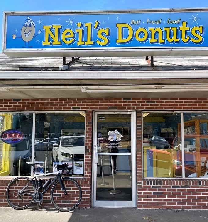 That smiling donut mascot on the sign knows something you don't: fresh donuts make everything better, friend.