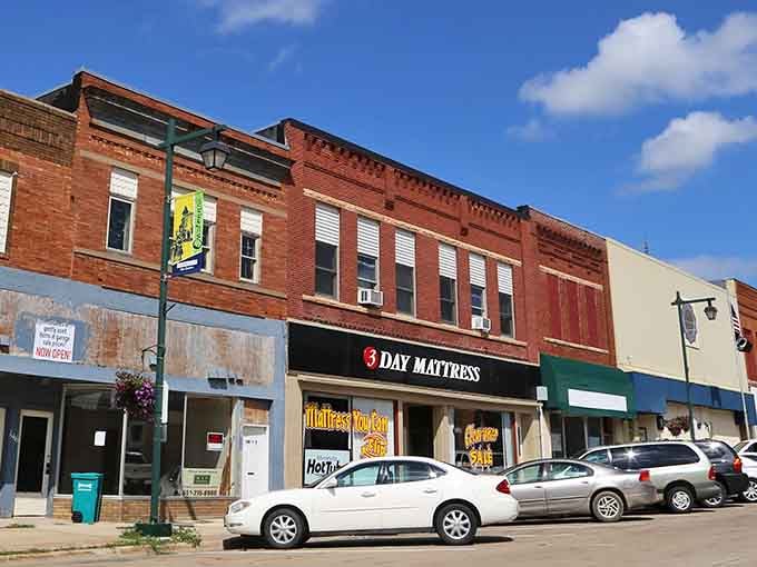 Red brick buildings stand proud under blue skies, each storefront holding decades of small-town stories and secrets.