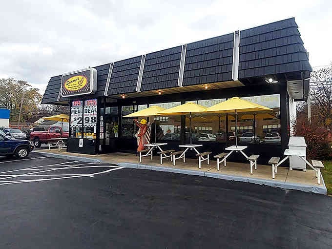The dramatic black roofline creates architectural drama worthy of a hot dog palace, complete with sunny yellow umbrellas.
