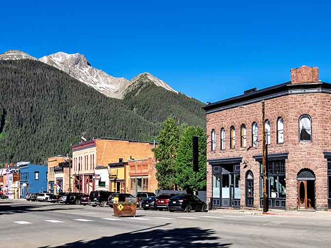 Snow-capped peaks tower over brick storefronts like nature's own skyscrapers watching over this historic mountain gem.