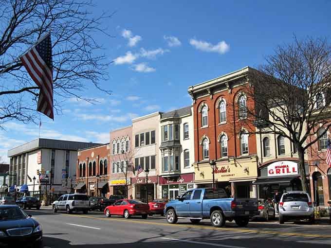 Main Street stretches wide under blue skies, where vintage storefronts and waving American flags remind you why small towns matter.