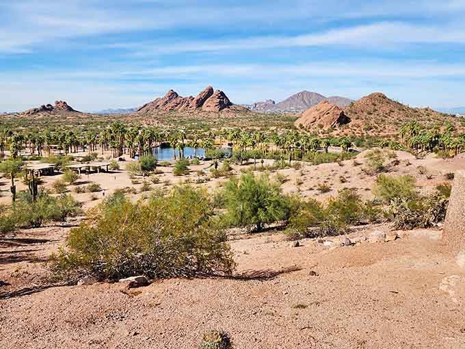 Desert palms and red rock peaks create an unexpected oasis that looks like something from an old Western movie.