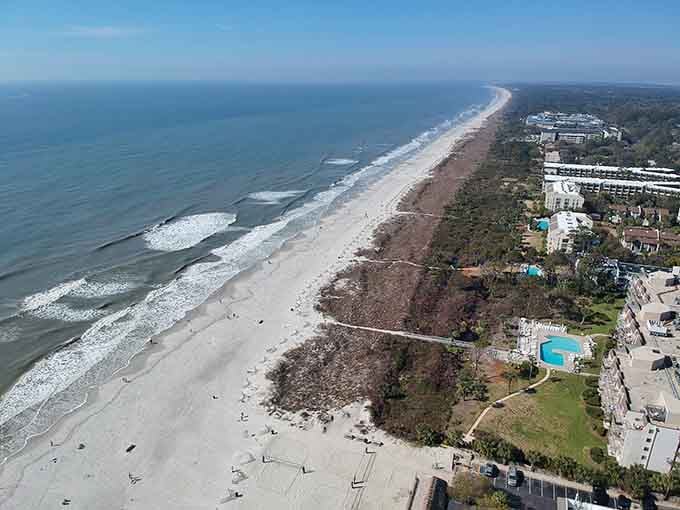 Miles of pristine coastline stretch endlessly where gentle waves meet soft sand under endless sky.