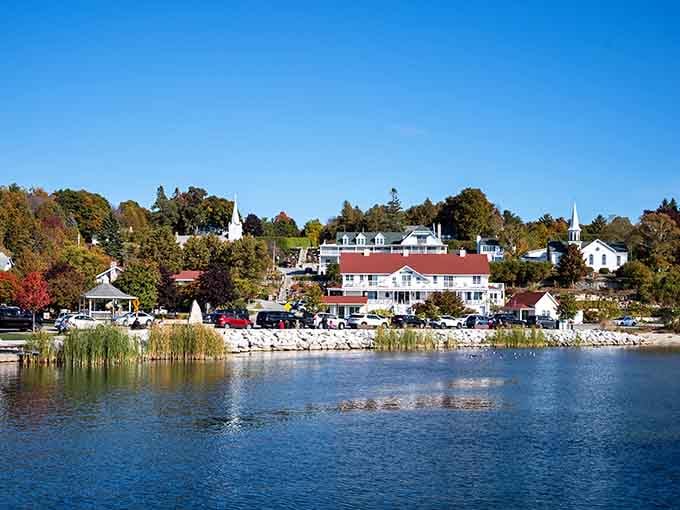 The harbor reflects white buildings and fall foliage like a mirror that decided to show off its best angle.