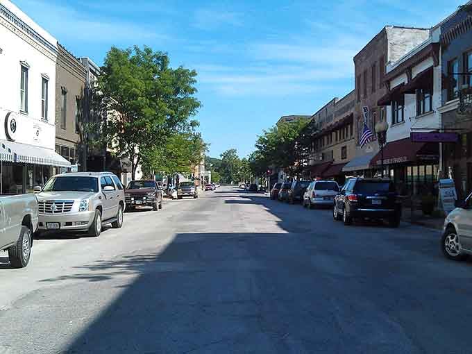 Flag flying, cars parked at angles, brick buildings standing tall&mdash;small-town perfection captured in one peaceful moment.