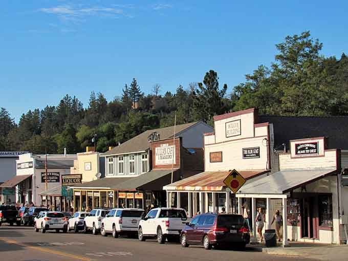 Pine-covered hillsides embrace this Main Street where shops nestle together like old friends sharing secrets under the California sun.