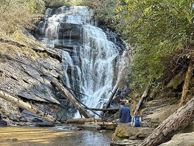 This waterfall tumbles over layered rock like a wedding cake made entirely of mountain spring water and pure magic.