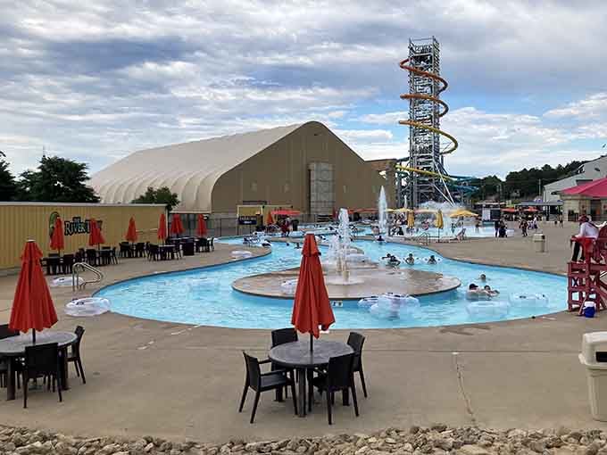 The outdoor pools gleam under cloudy skies, offering families a refreshing escape with slides towering in the distance.