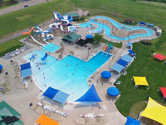 Swimmers packed into Splash Valley's shimmering pool on a golden afternoon, with those bold yellow and green slides beckoning everyone closer.