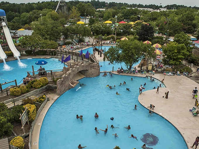 The stone bridge arching over sparkling pools creates a scene straight from a vacation postcard dream.