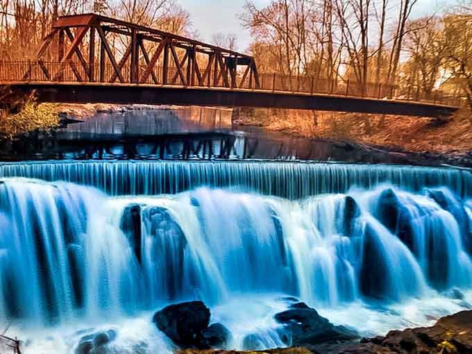 Golden hour transforms rushing water into liquid light, with that charming bridge adding a storybook touch.