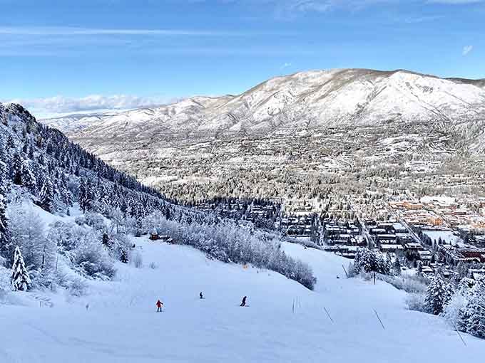 Snow-covered slopes overlook the valley below, where skiers carve turns and gravity does the heavy lifting.