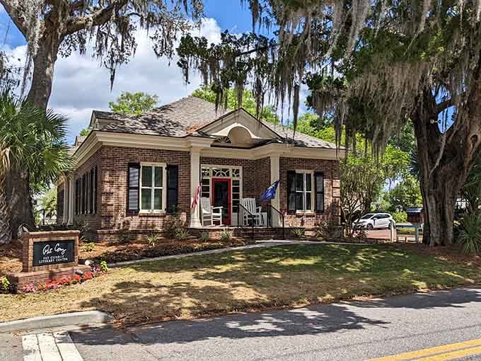 Spanish moss draping those ancient oaks creates nature's own cathedral, framing this charming brick building perfectly beneath.