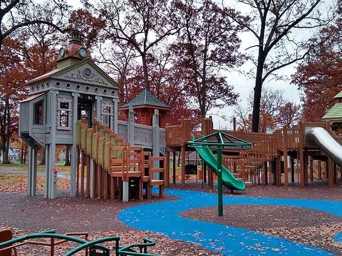 Autumn leaves carpet this whimsical playground where Victorian-style playhouses meet modern fun for the grandkids.