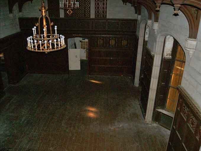 Even decay can't diminish the ornate chandelier hanging like a golden ghost above this hall.