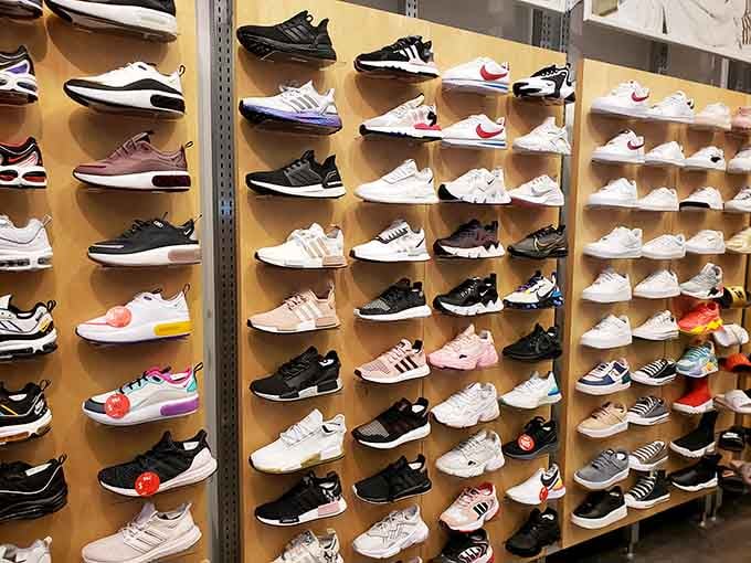 A sneaker wall that would make Imelda Marcos weep with joy, organized by color like a rainbow of regret.