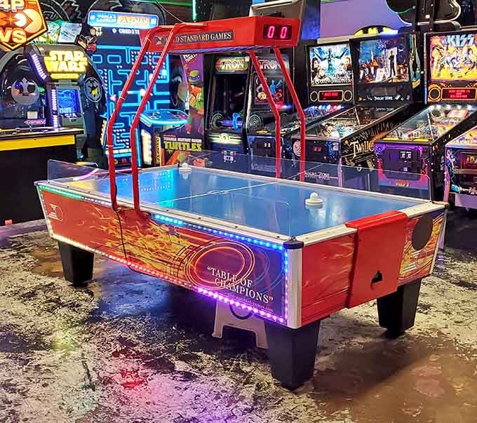 Air hockey tables gleaming under neon, where friendships are tested and trash talk reaches Olympic-level heights every single game.