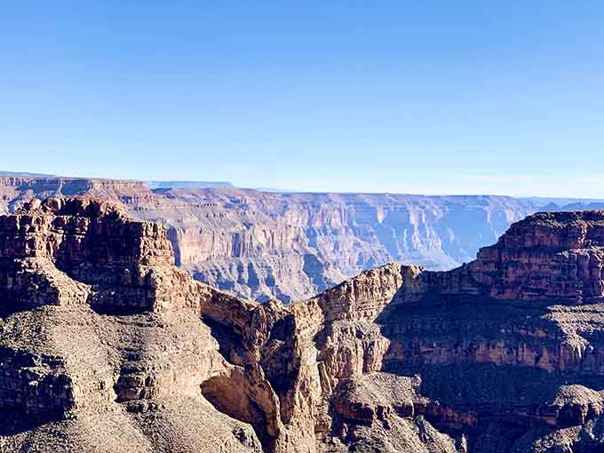 Towering rock formations stand sentinel over the vast expanse, silent witnesses to millions of years of transformation.