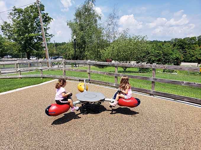 Little ones discovering the simple joy of spinning toys near the farm area, creating memories that'll last way longer than screen time.