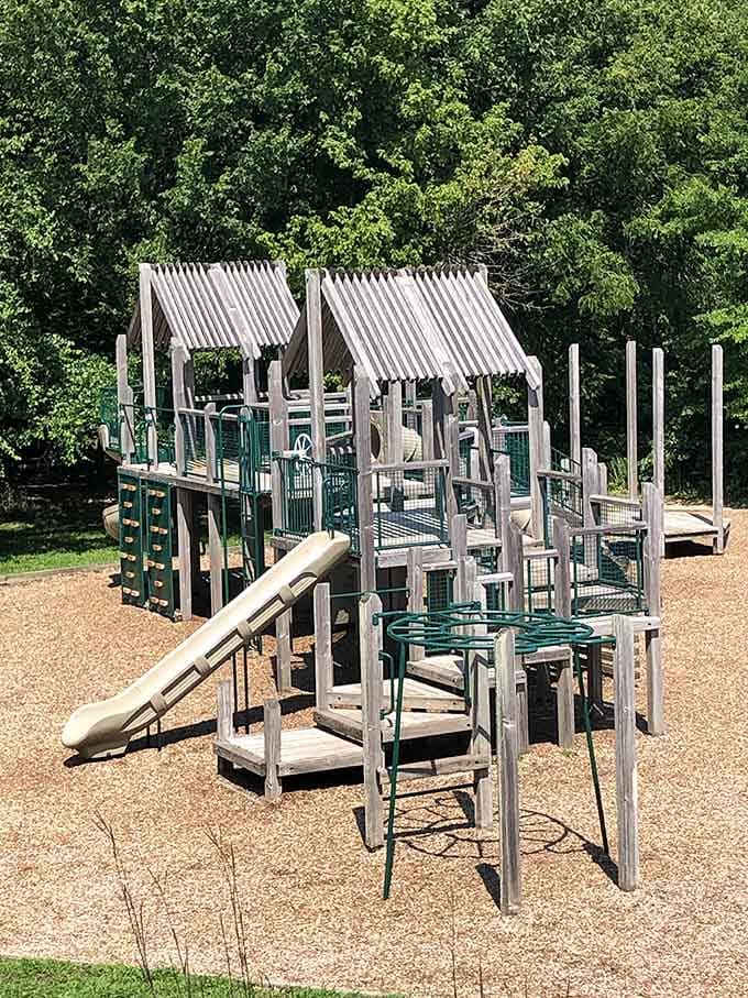 Those striped awnings give serious vintage carnival vibes while kids conquer this multi-level climbing adventure at the park.