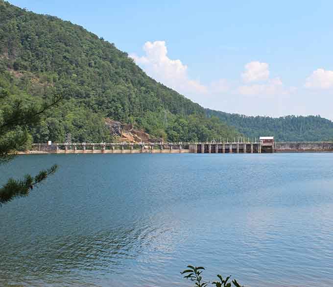 The Tugalo Dam stretches across these mountain waters like nature's own architectural masterpiece framed by endless green hills.