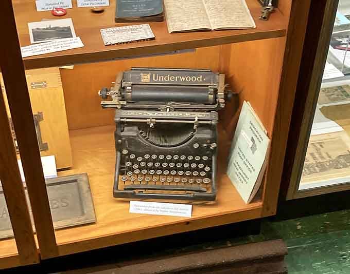 An Underwood typewriter that probably clacked out more drama than a modern Twitter feed, beautifully preserved behind glass.