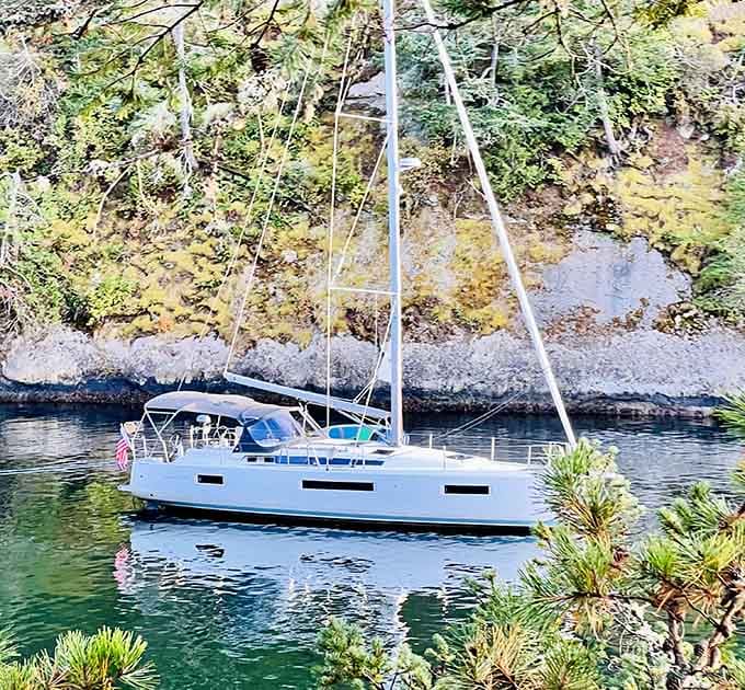 Sailboats anchored in crystal-clear water surrounded by forest. This is what retirement dreams are made of, folks.