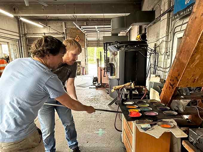 Two artists gather molten glass from the furnace, beginning the delicate dance between heat and human intention.