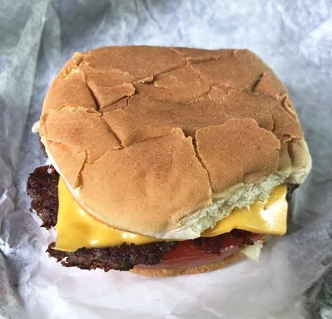 Behold the cheeseburger in its natural habitat: perfectly melted cheese cascading over a juicy patty like edible lava.