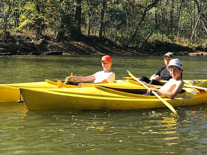 Three kayakers in perfect formation, looking like they've been doing this since before smartphones were invented.