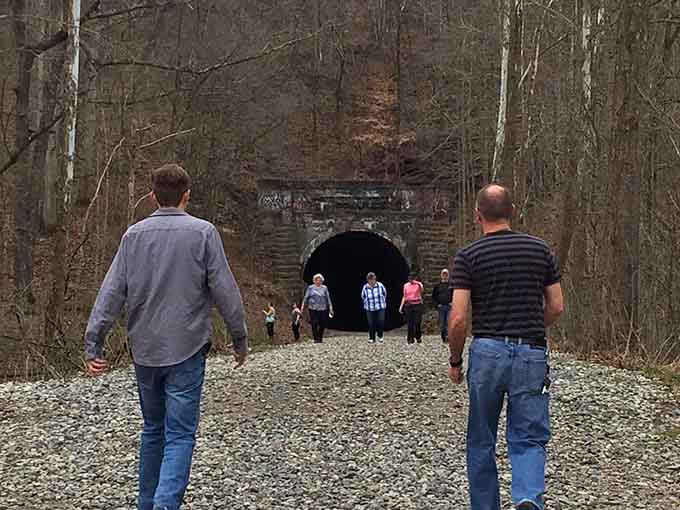 Two visitors approach the darkness ahead, probably debating who goes first and who gets to hold the flashlight.