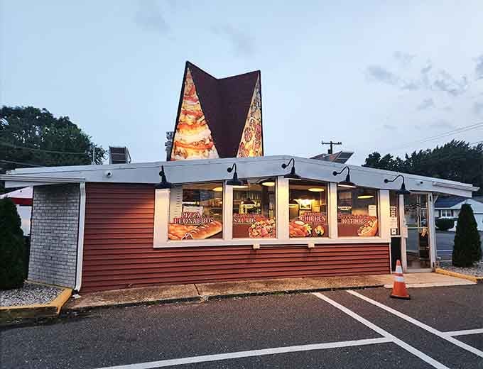 That distinctive pizza slice sign is basically a beacon of hope for hungry beachgoers everywhere.