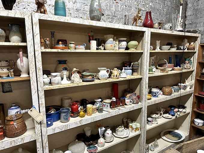 Weathered shelves overflow with colorful pottery and glassware, each piece carrying stories from someone's cherished collection.