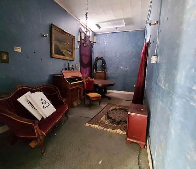 Vintage furniture frozen in time, waiting for conversations that will never resume in this haunting blue room.