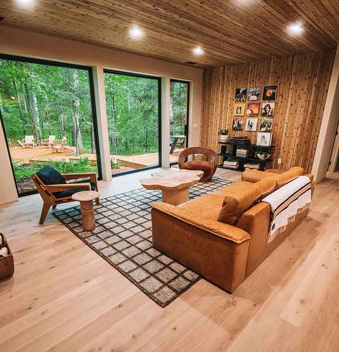 Floor-to-ceiling windows prove that the best television programming is actually just watching leaves rustle in the breeze.