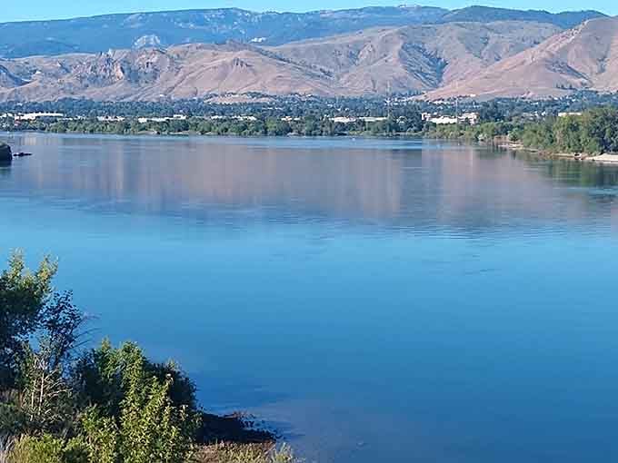 The Columbia River reflects sky and mountains so perfectly, you'll wonder if someone installed a giant mirror for dramatic effect.