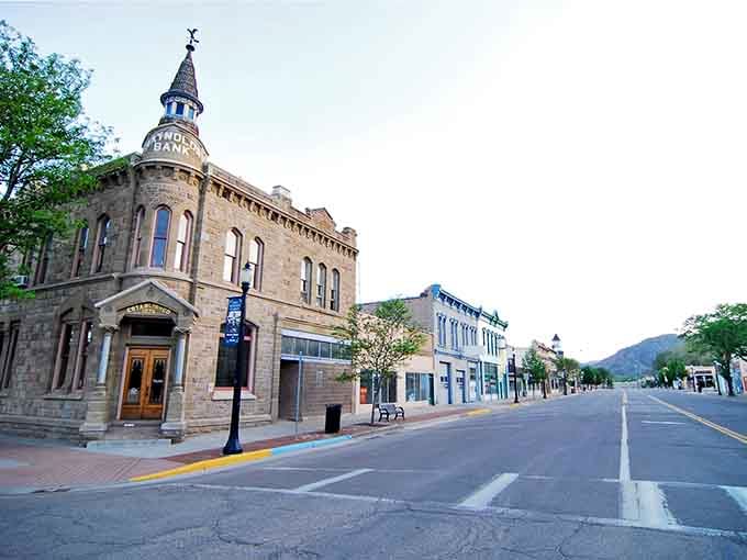 That stone bank building has seen generations pass while the mountains behind it never age a day.
