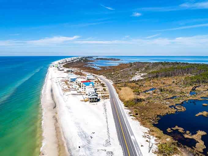 A ribbon of white sand curves between emerald waters and wild coastline in perfect harmony.