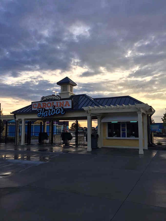Carolina Harbor's entrance glows under dramatic sunset clouds, promising coastal adventures just beyond those gates inside.