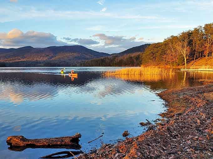 Mountain-framed cove sparkles beneath clear skies, perfect for paddling into nature's peaceful embrace.