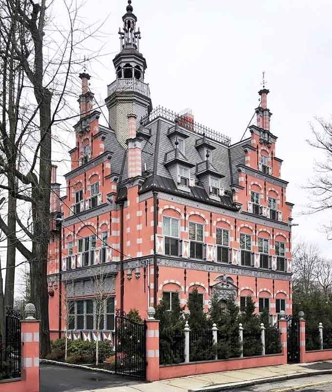 The iron fence frames this Dutch Renaissance beauty like a velvet rope around architectural royalty that demands your attention.