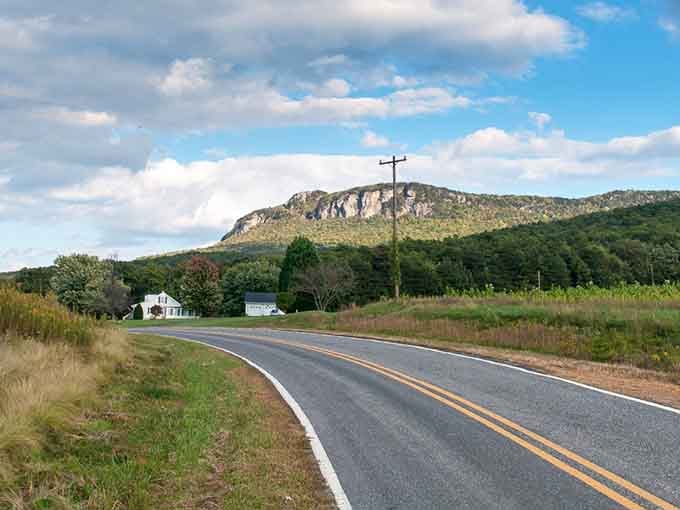 That dramatic rock face rising from the fields looks like nature's own cathedral reaching toward the clouds.