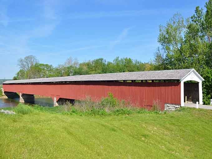 Stretching across the landscape like a rustic ribbon, this coral-hued bridge connects past and present with timeless grace.