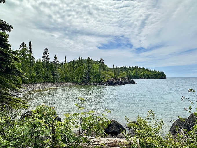 Rocky shoreline meets endless Superior blue where pine-covered islands dot the horizon like nature's own archipelago masterpiece.