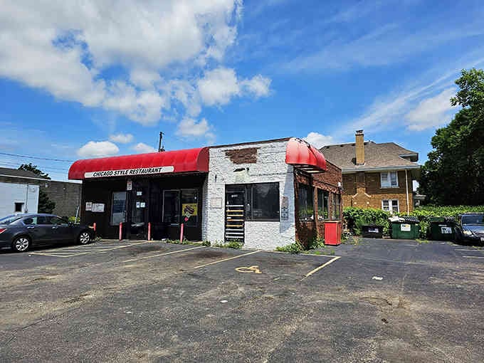 The red awnings pop against white brick like ketchup on a perfectly grilled frank, classic and inviting.