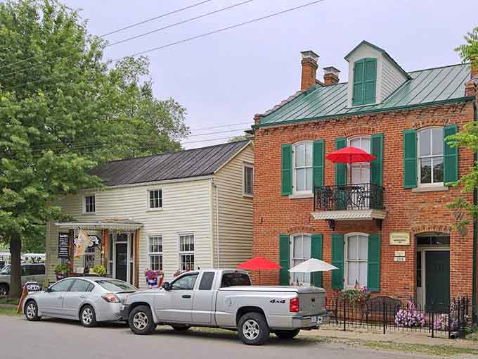 Green shutters and red umbrellas add cheerful pops of color to these charming riverside buildings.