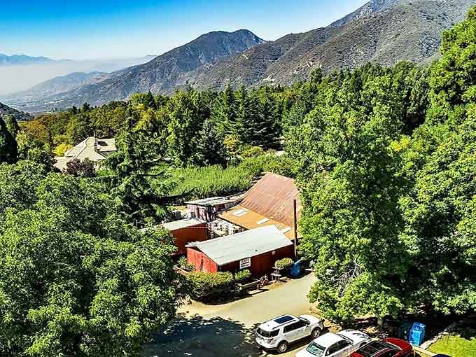 Nestled among green orchards and mountain slopes, this red barn sits ready to welcome visitors seeking fresh mountain air.