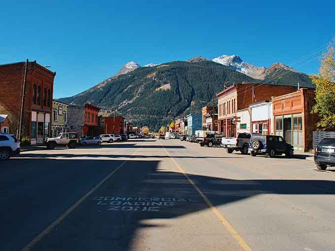 Snow-dusted peaks tower over Silverton's brick buildings, proving that some postcards are actually real places you can visit.