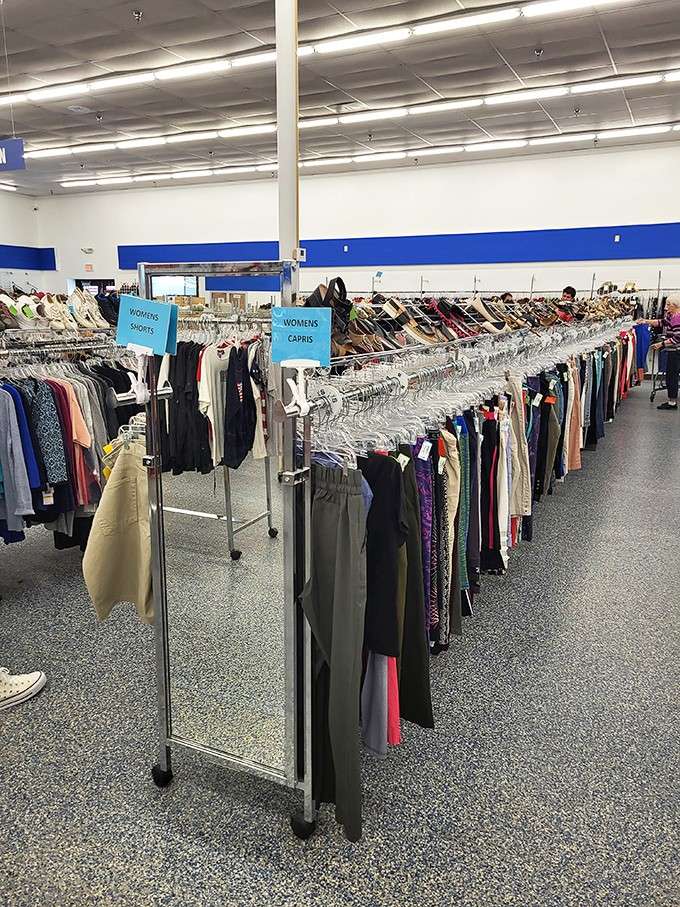 Bright blue signs guide you through endless racks of women's capris and shorts, organized like a department store dream.